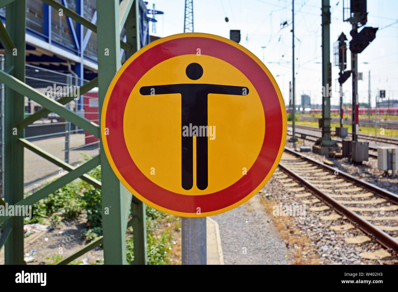 Yellow and red round warning sign with person at the end of train ...