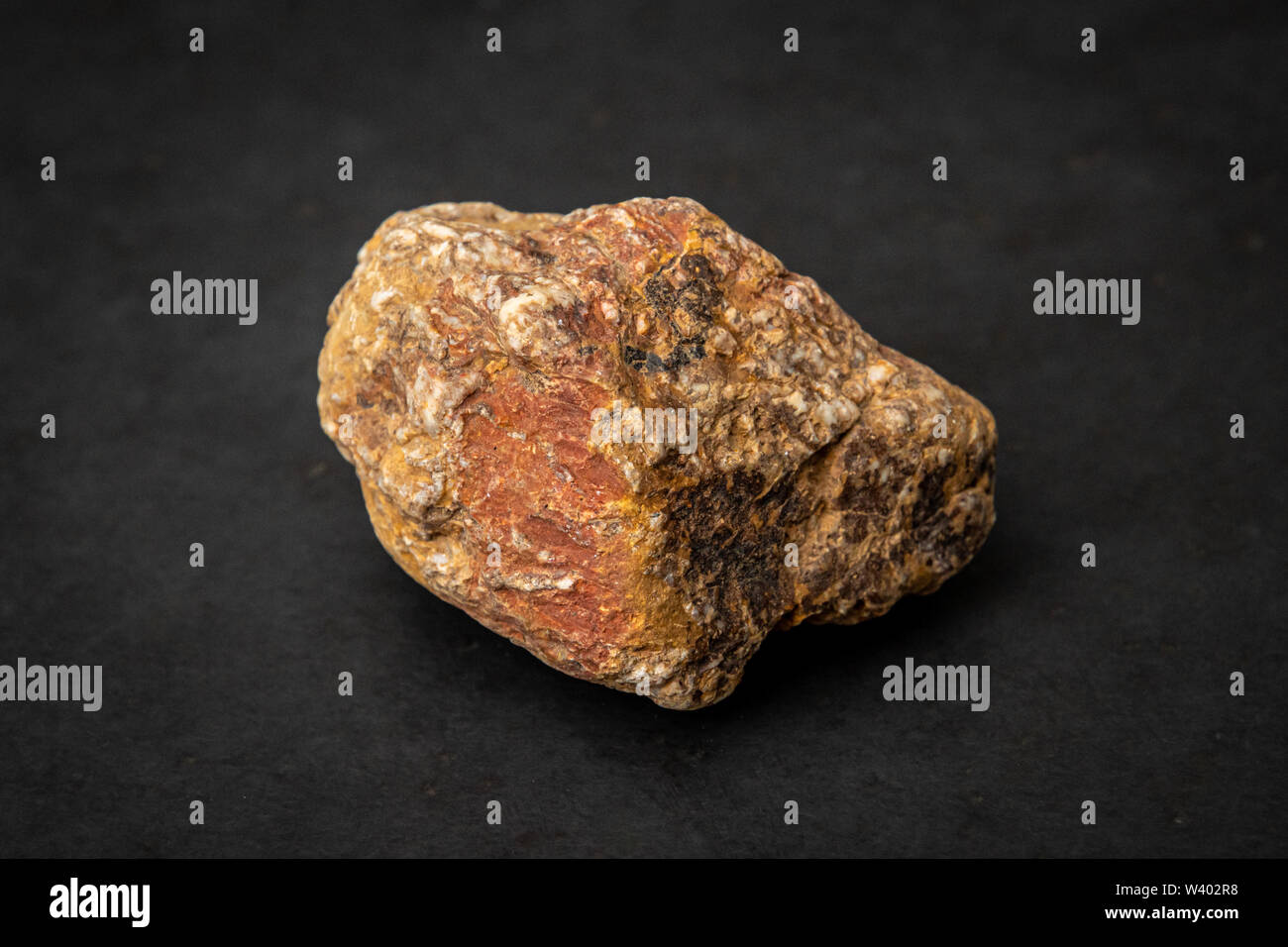 Partly metamorphic rock containing red, yellow and white components ...