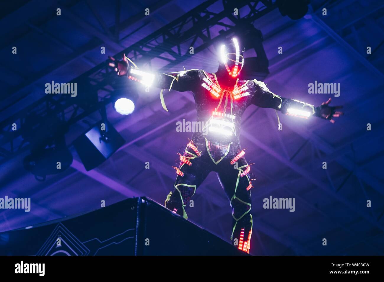 Male performer wearing a white and red led suit standing on a high ...
