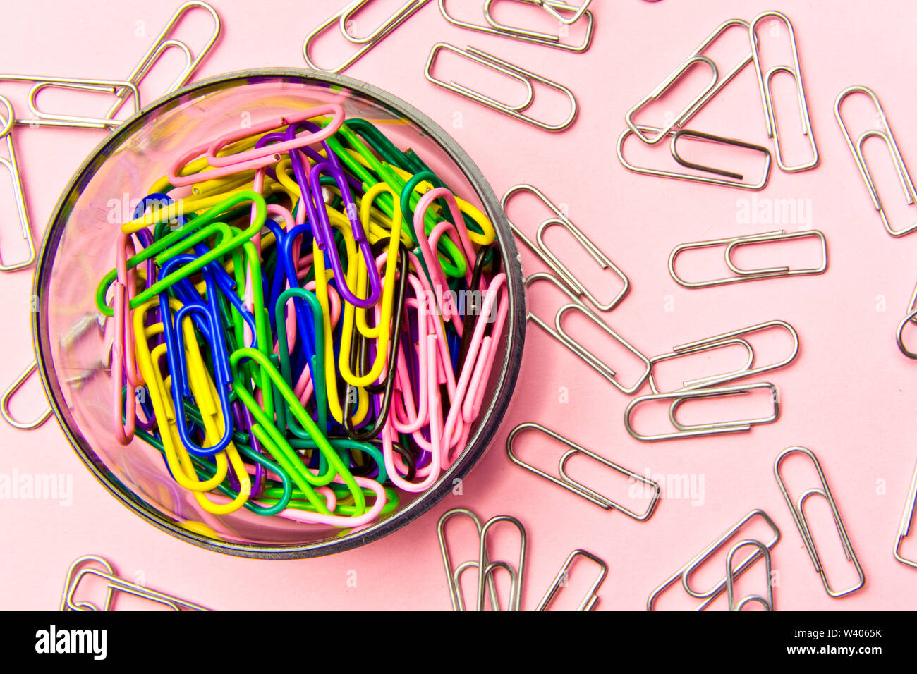 The concept of order and chaos. Chaotic scattered silvery paper clips ...