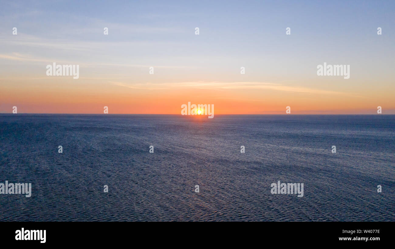 Sunset over the sea in clear weather, view from above. Seascape with ...