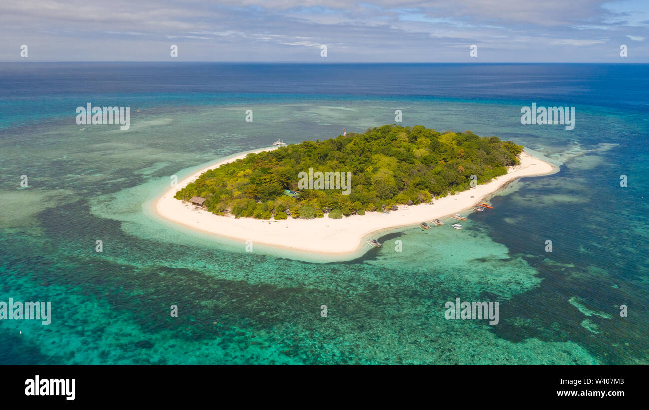 A small island surrounded by azure water and coral reefs, a top view ...