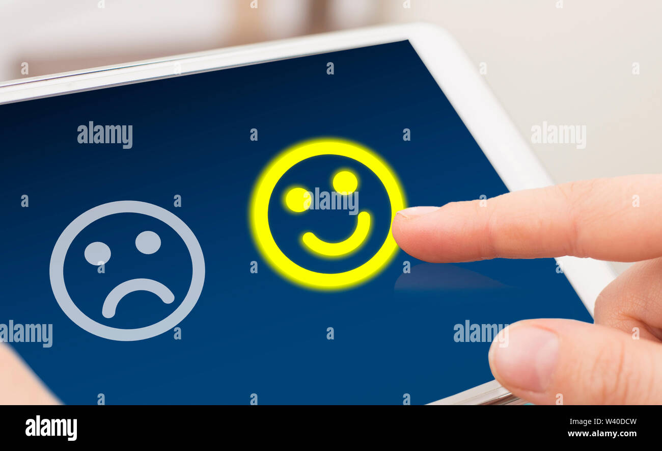 finger touching smiley face sign on the screen to vote for business ...