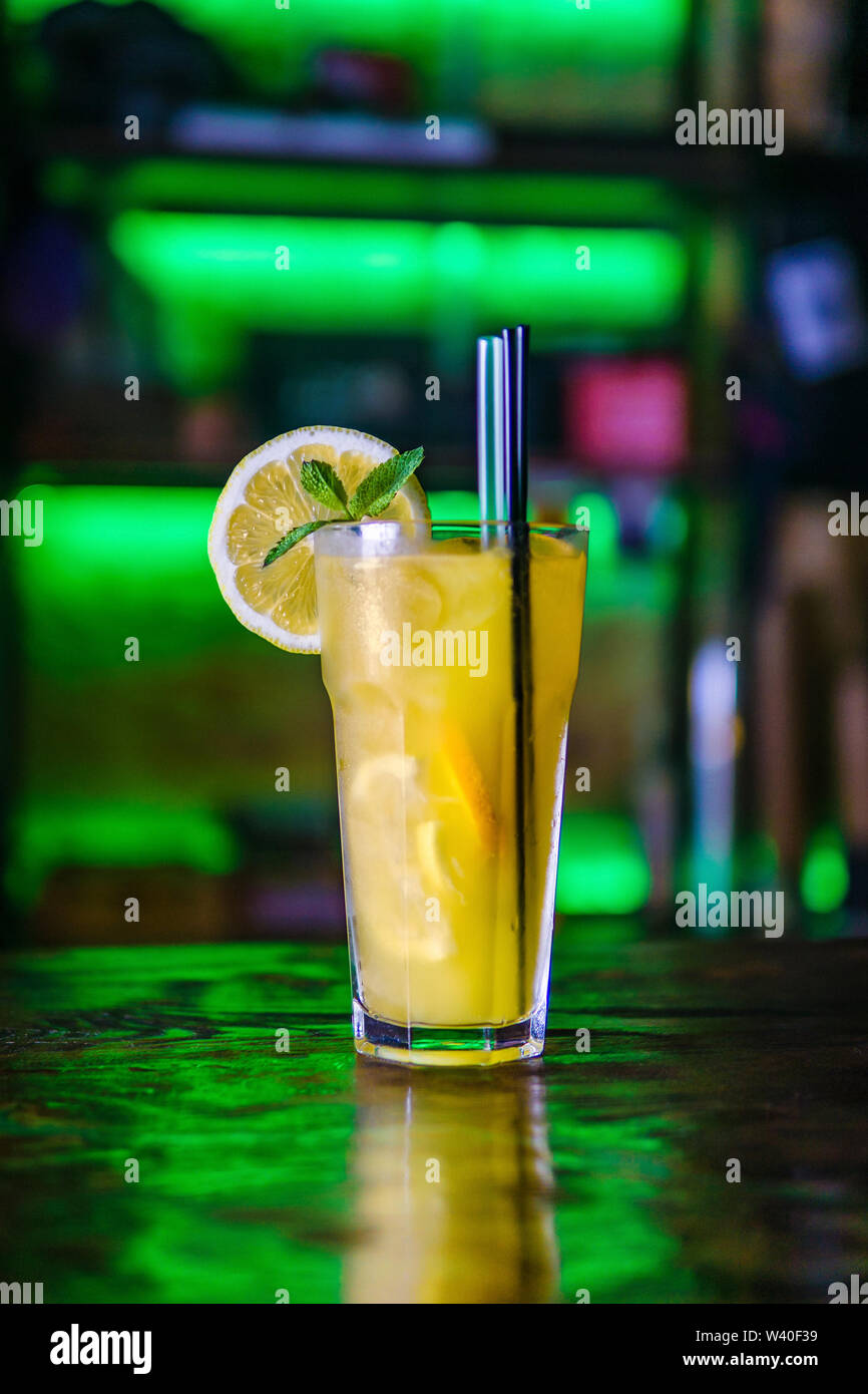 Orange cocktail in a tall glass and a slice of lemon Stock Photo - Alamy