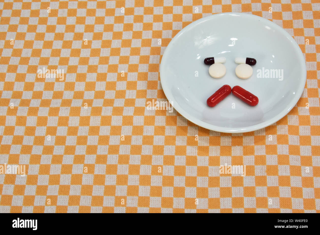 Sad face expression made of medicine. pain medication tablets. colored ...