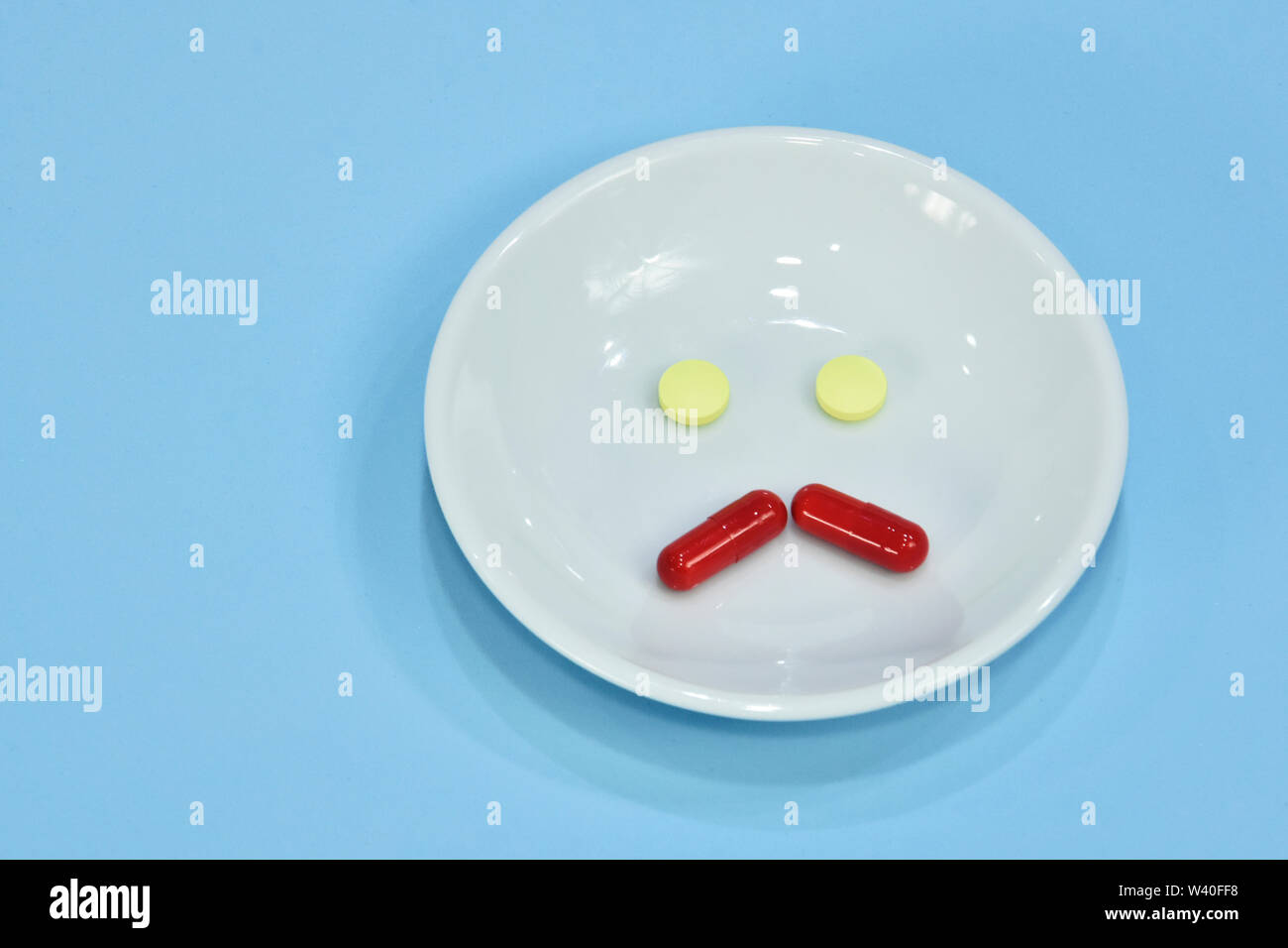 Sad face made of medicine. pain medication tablets. colored pills on ...