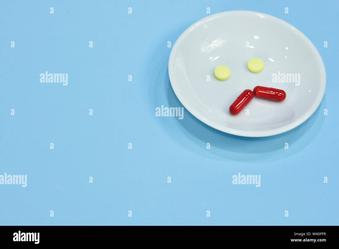 Sad face made of medicine. pain medication tablets. colored pills on ...