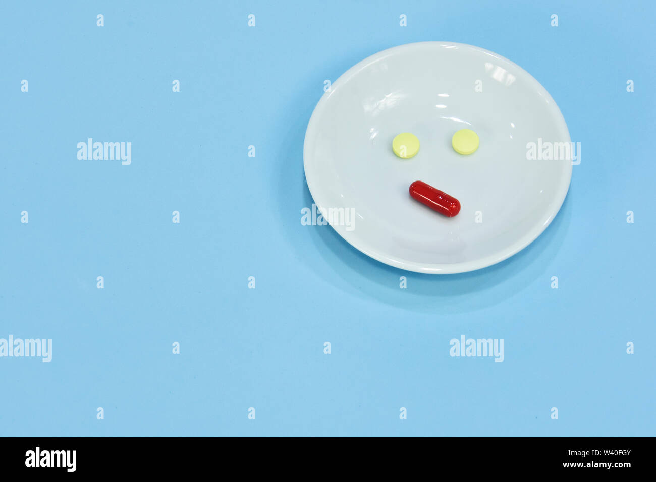 Sad face made of medicine. pain medication tablets. colored pills on ...