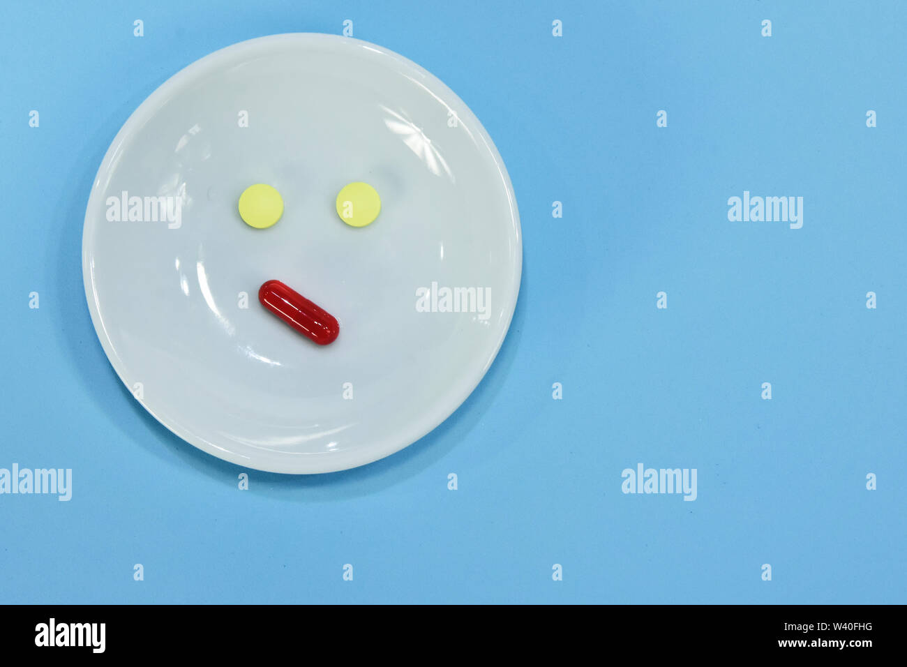Sad face made of medicine. pain medication tablets. colored pills on ...