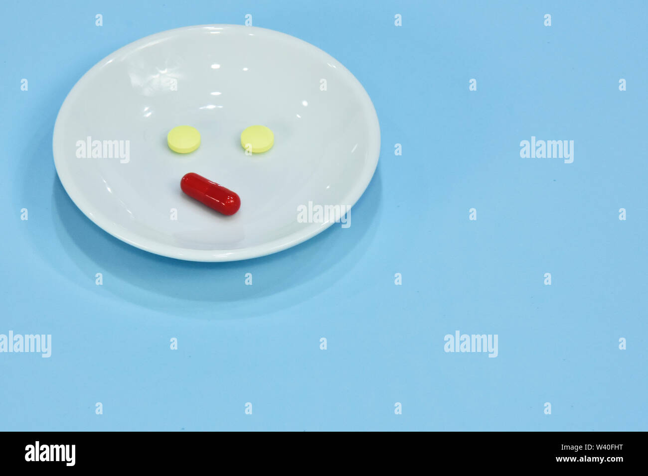 Sad face made of medicine. pain medication tablets. colored pills on ...