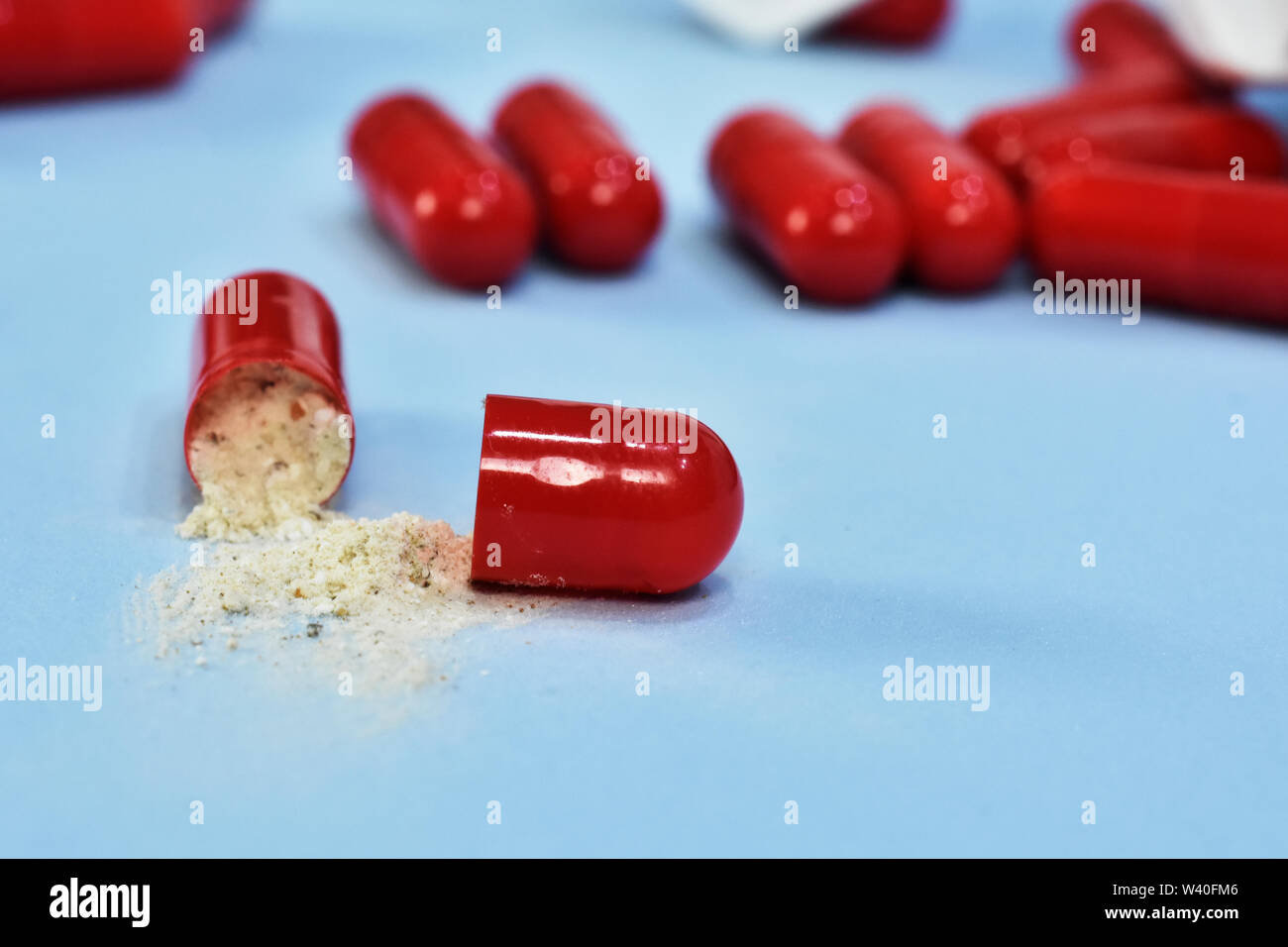 Open capsule with powder coming out. Dosing with opened suddenly tablet ...