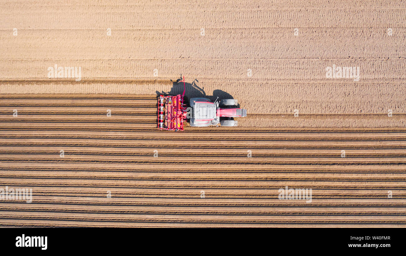 Tractor on a plowed field, top view. Agricultural field for planting ...