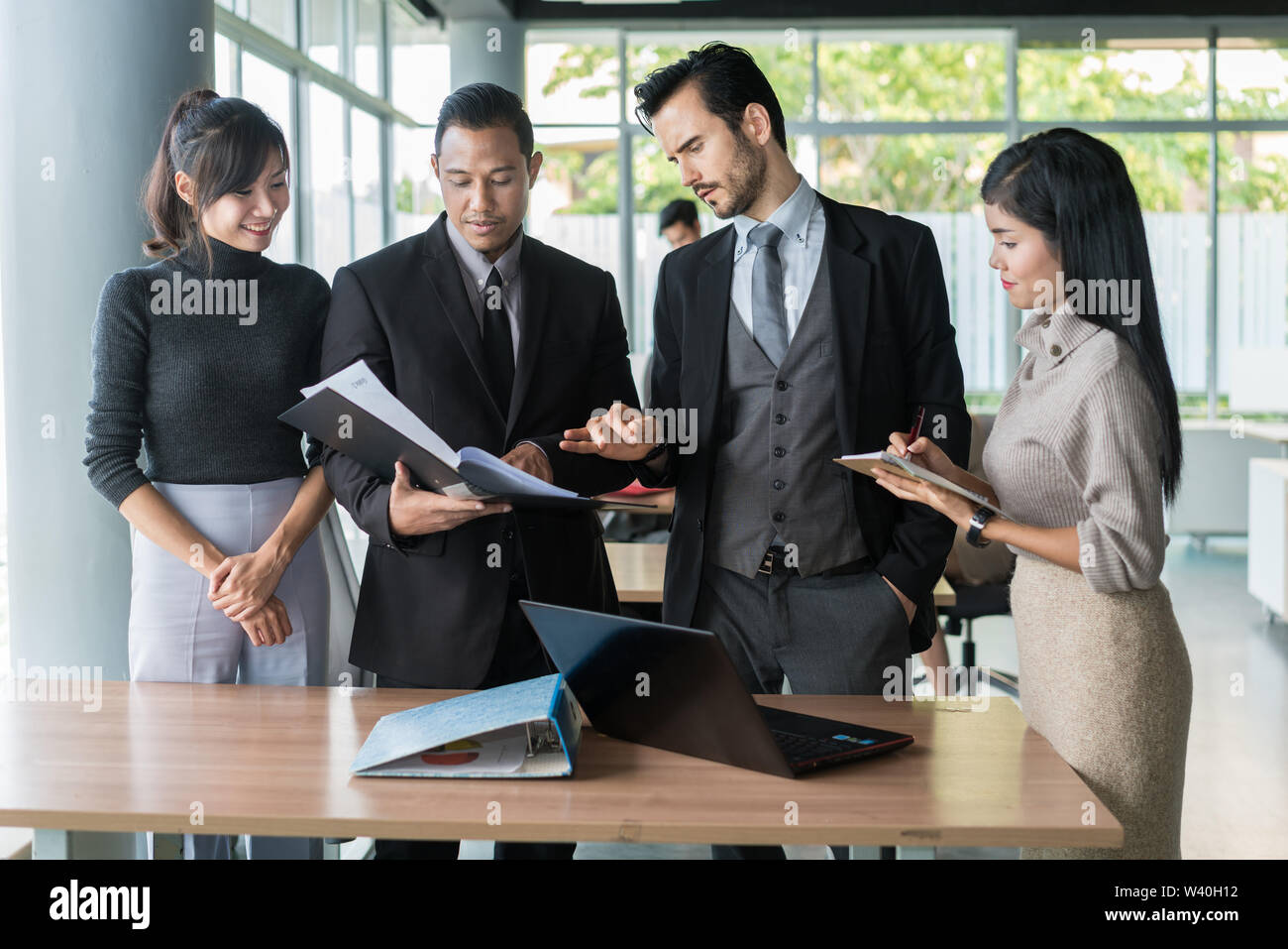 Smart manager explaining internal meeting to his project team in modern ...