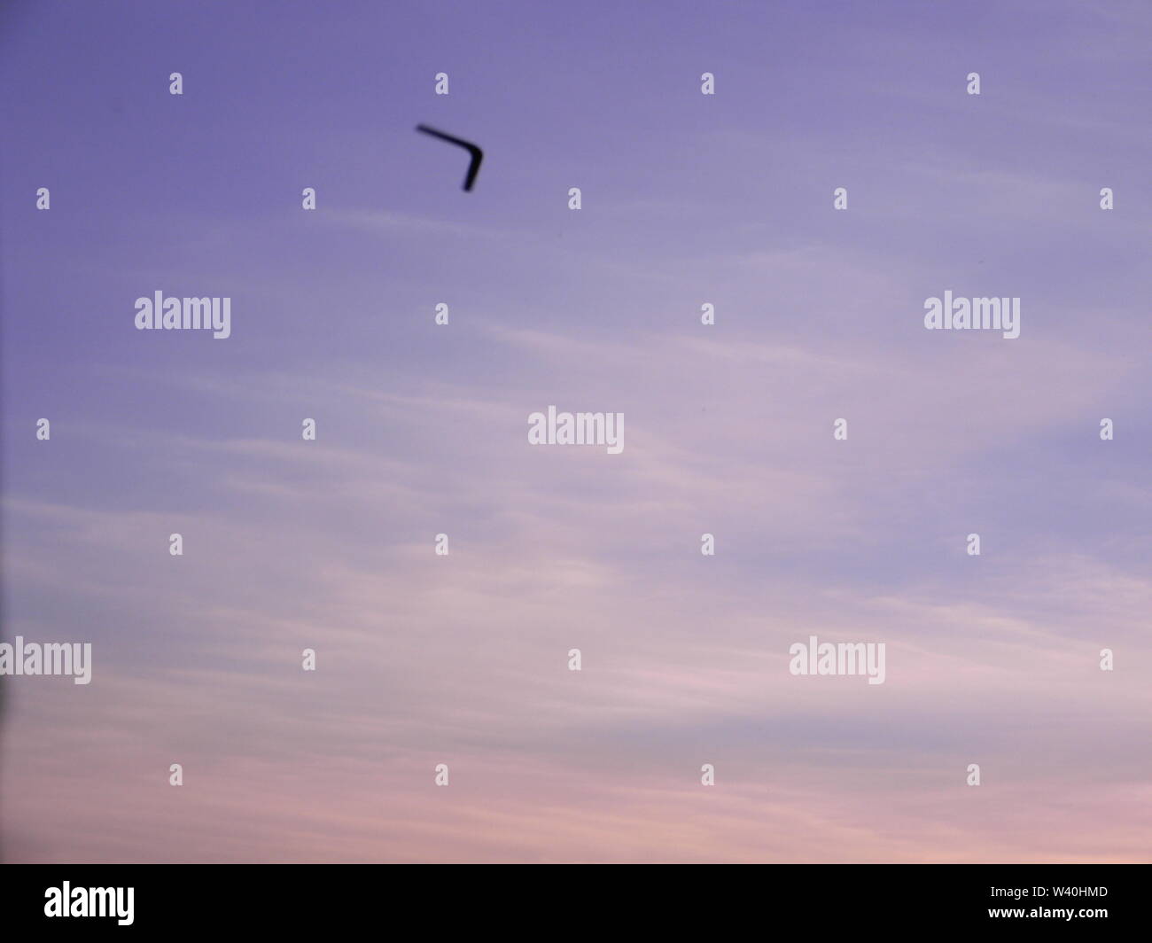 New boomerang in flight against of pure white clouds and blue sky Stock ...