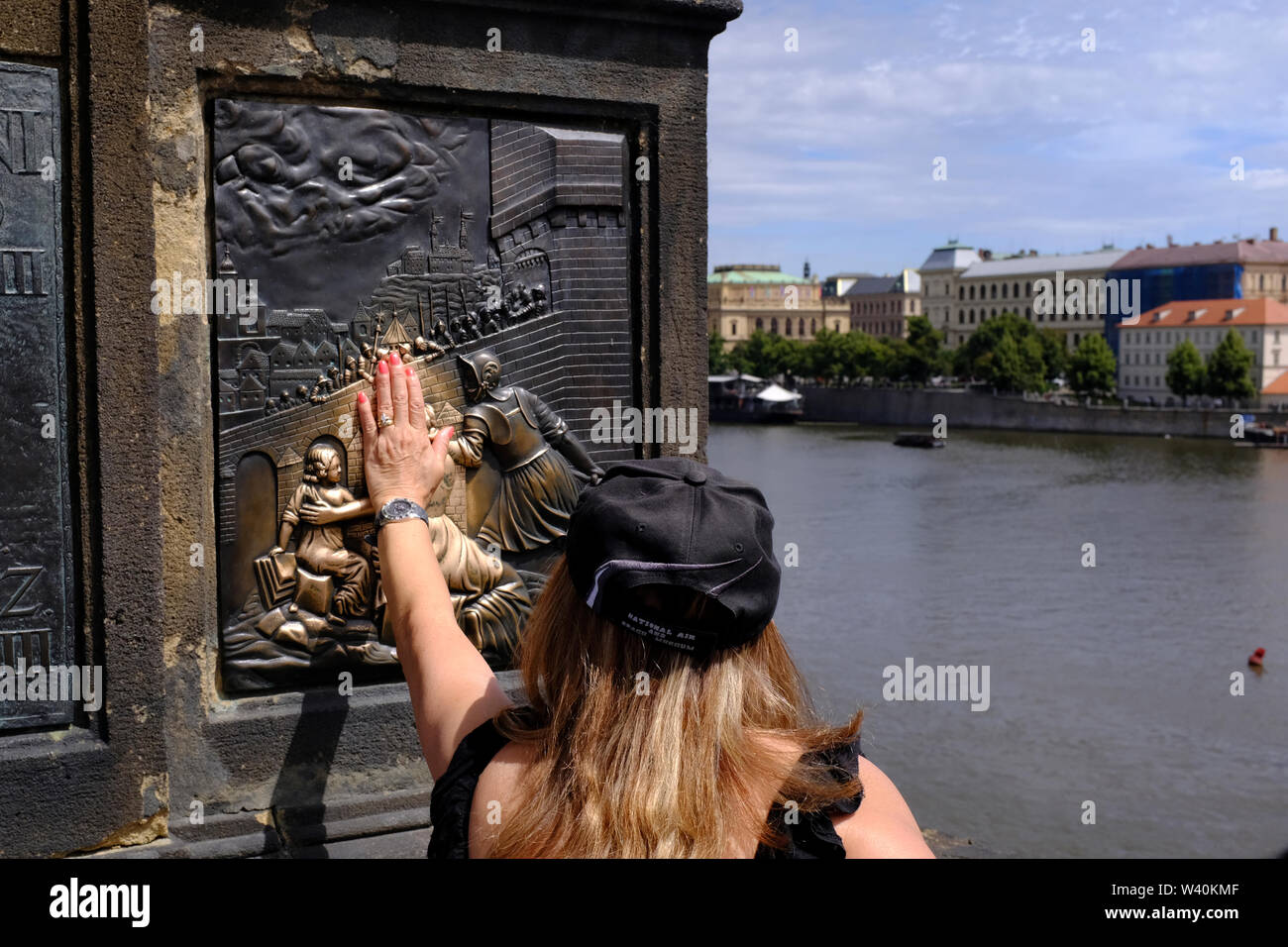 Tourists touching the Good Luck Statue of St John Nepomuk, on the ...