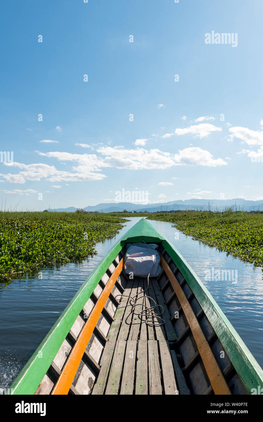 Vertical picture of tour boat sailing in the middle of nature in Inle ...