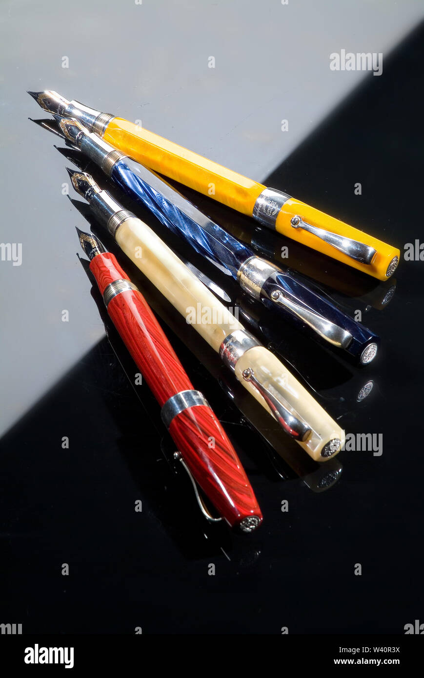 Four different pens on a glass background with highlight Stock Photo ...