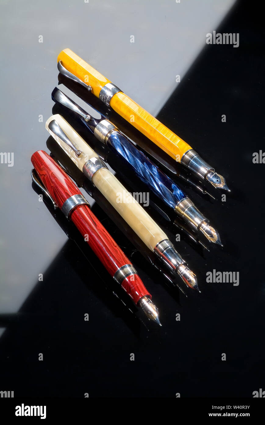 Four different pens on a glass background with highlight Stock Photo ...