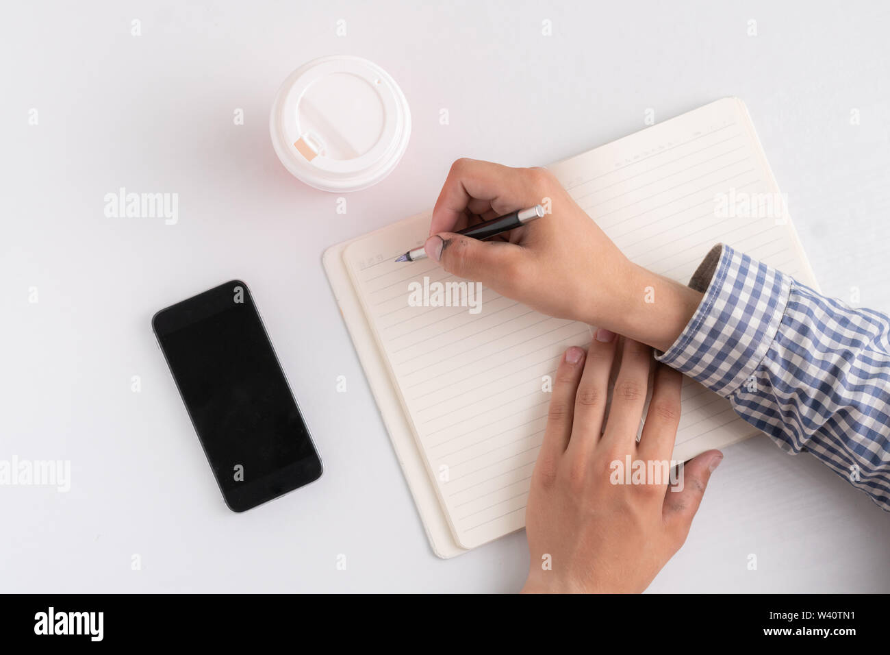 top view of hands with pen taking notes at his workplace, copy space ...