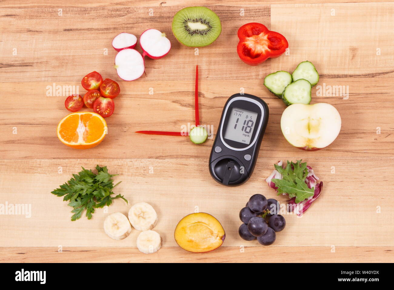 Glucometer with result sugar level and clock made of fruits and ...