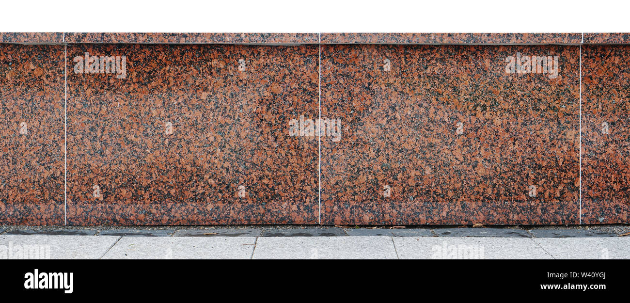 Wall from big red granite polished blocks are connected together by ...