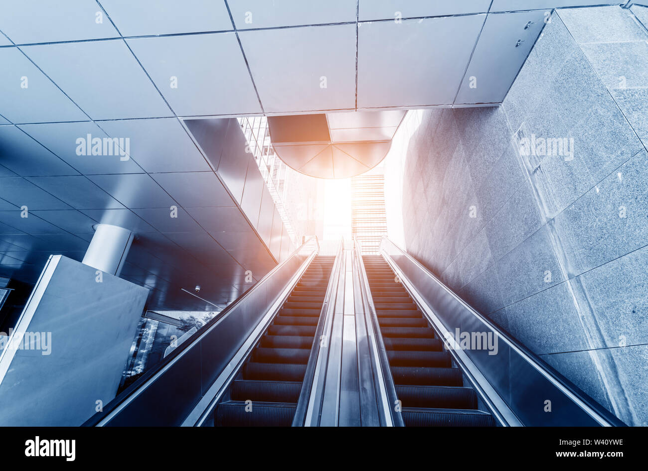Escalator entering the overpass through modern buildings Stock Photo ...