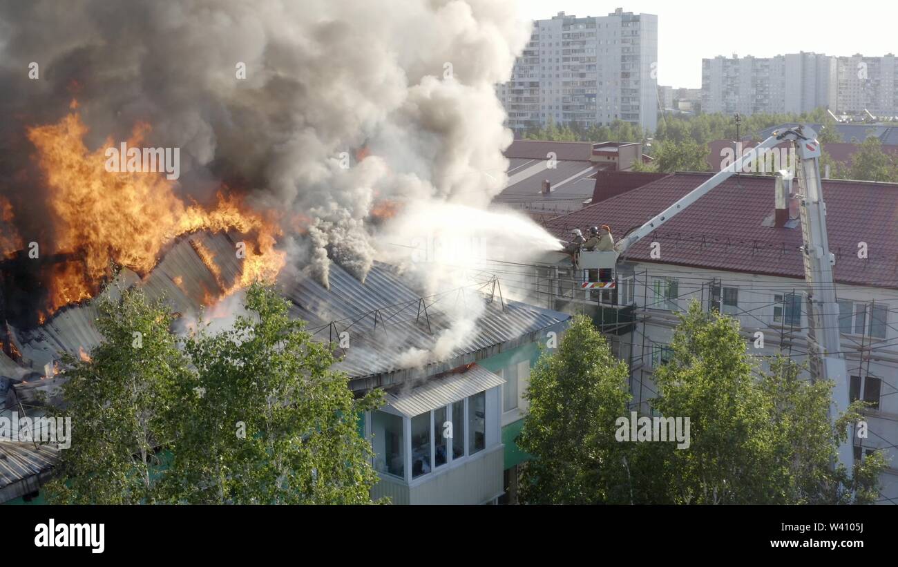 Burning roof of a residential high-rise building, clouds of smoke from ...