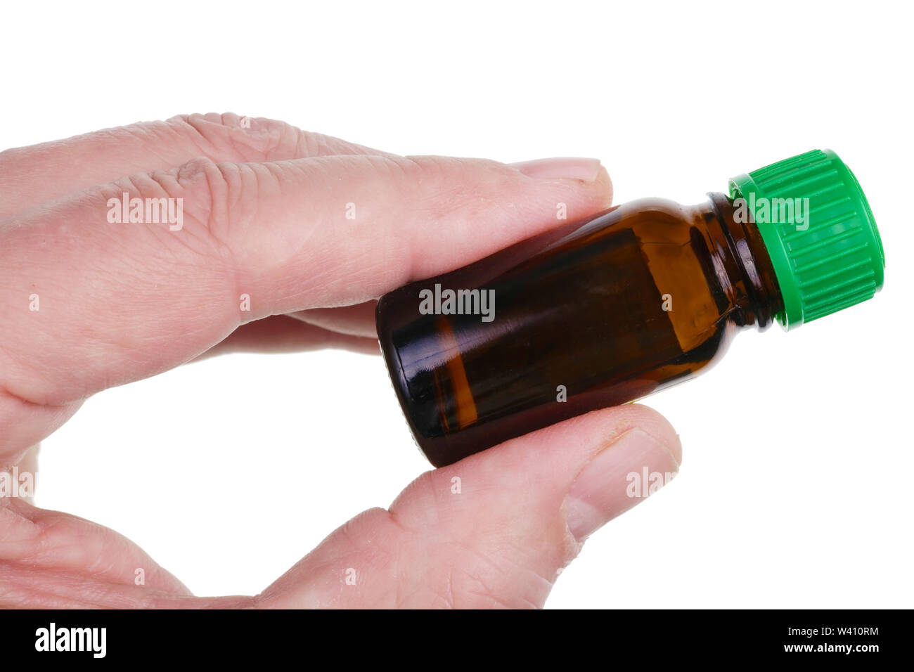 An elderly man holds in his hand an old vial with poisonous yellow oil ...