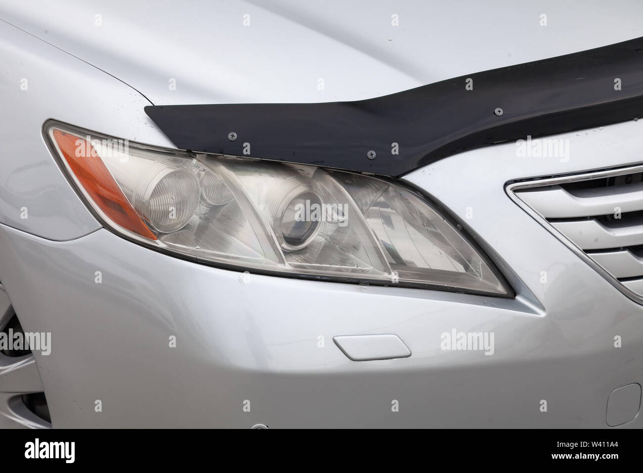Front headlight view of car in silver color after cleaning and ...