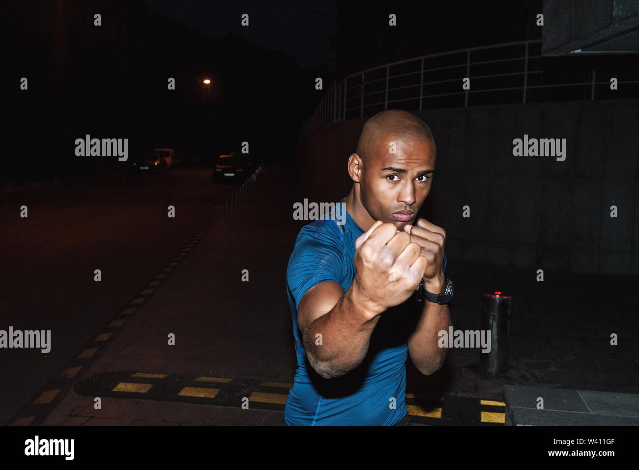 Image of a handsome strong african sports man boxer at night outoors ...