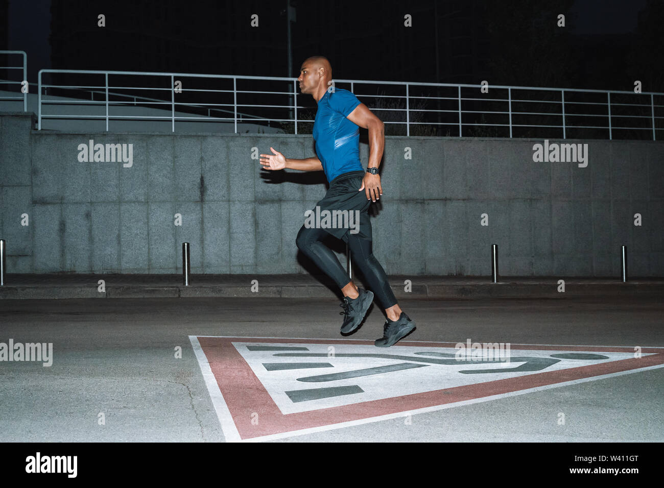 Image of a handsome strong african sports man runner at night outoors ...
