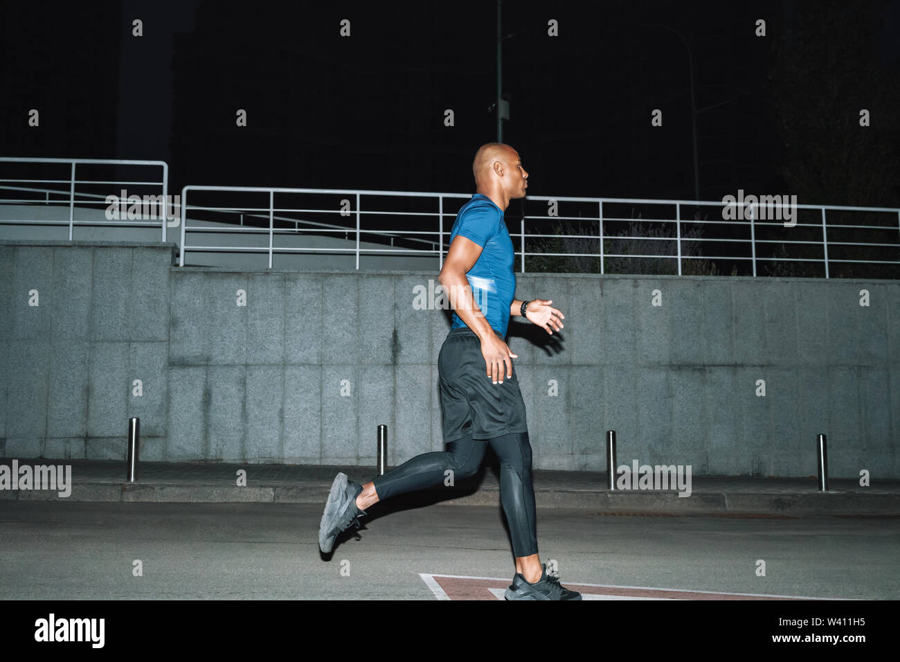 Image of a handsome strong african sports man runner at night outoors ...