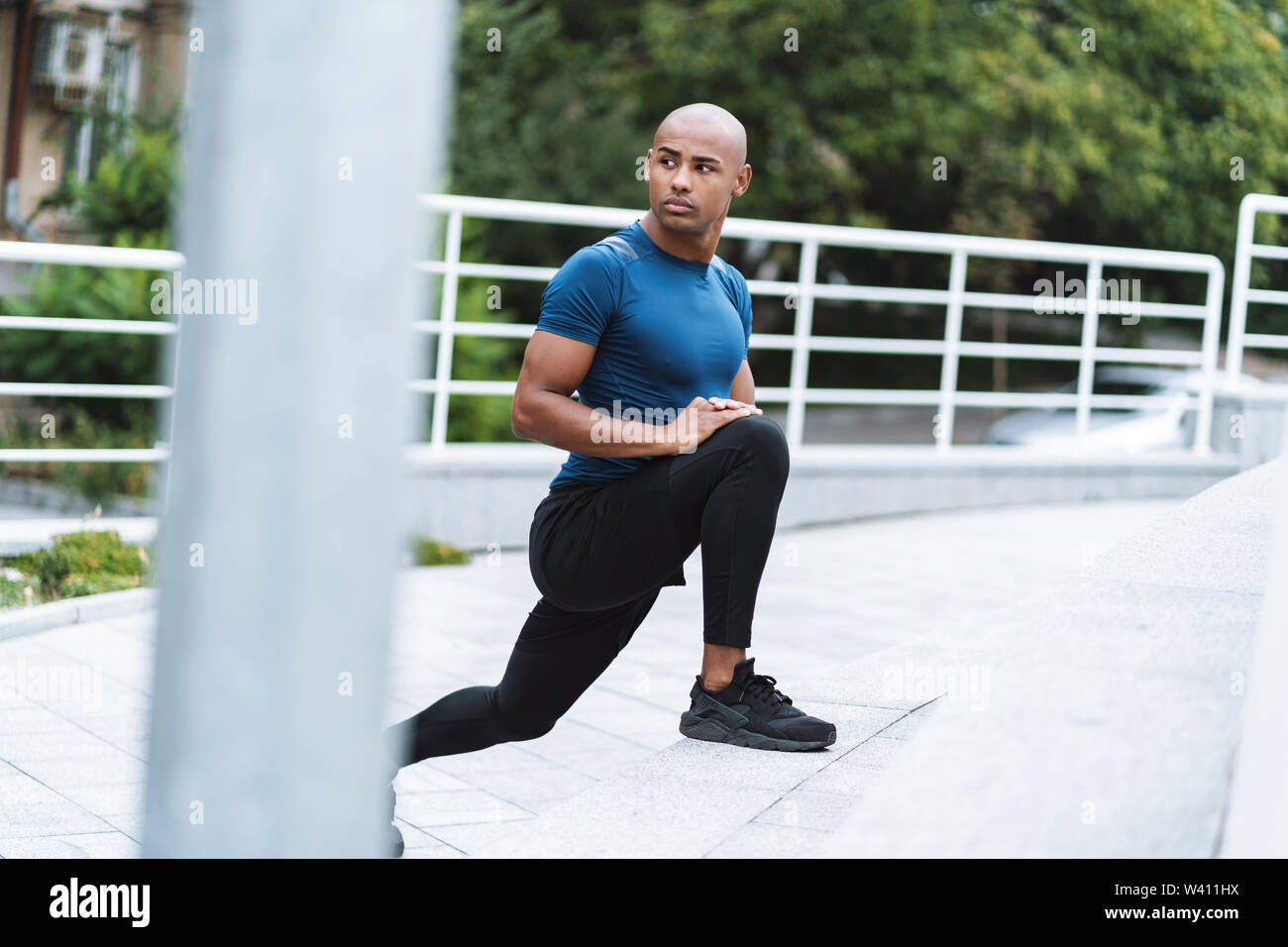 Image of handsome young strong sports man make stretching exercises ...