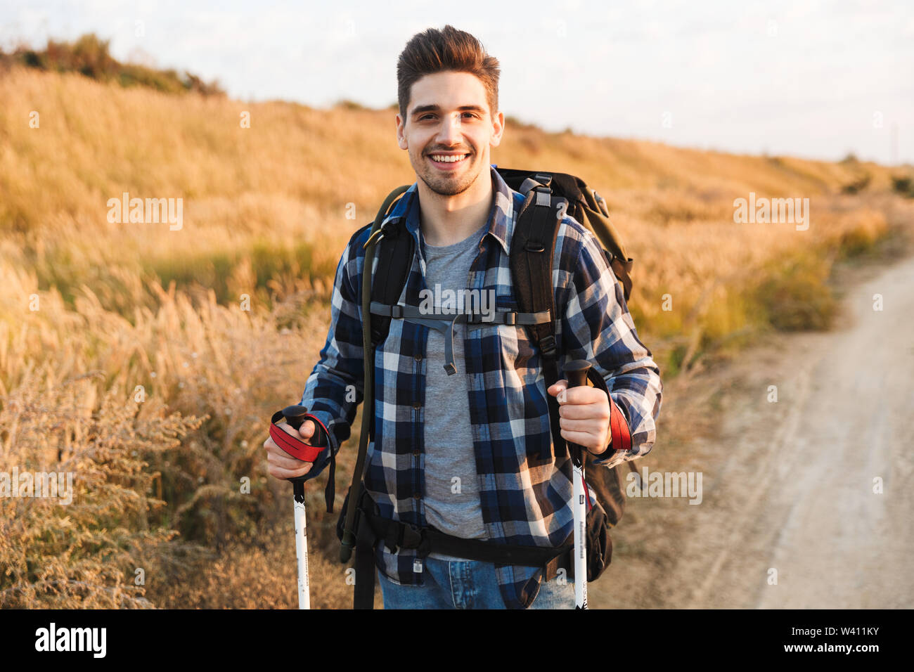 Attractive young man carrying backpack, hiking Stock Photo - Alamy