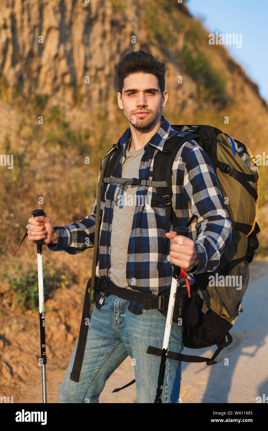 Attractive young man carrying backpack, hiking Stock Photo - Alamy