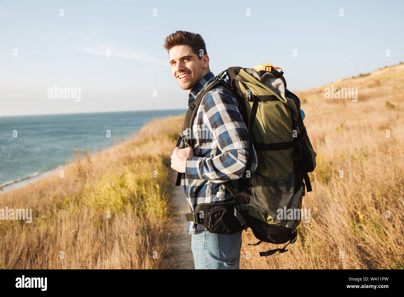 Attractive smiling young man carrying backpack, hiking Stock Photo - Alamy Attractive smiling young man carrying backpack, hiking Stock Photo - Alamy