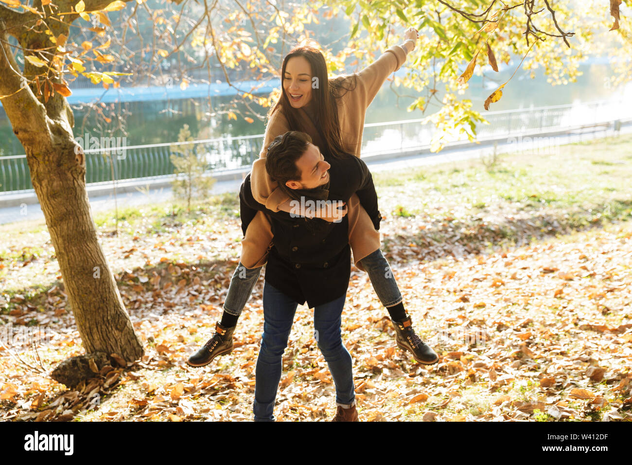 Cheerful young couple spending fun time at the park in autumn ...