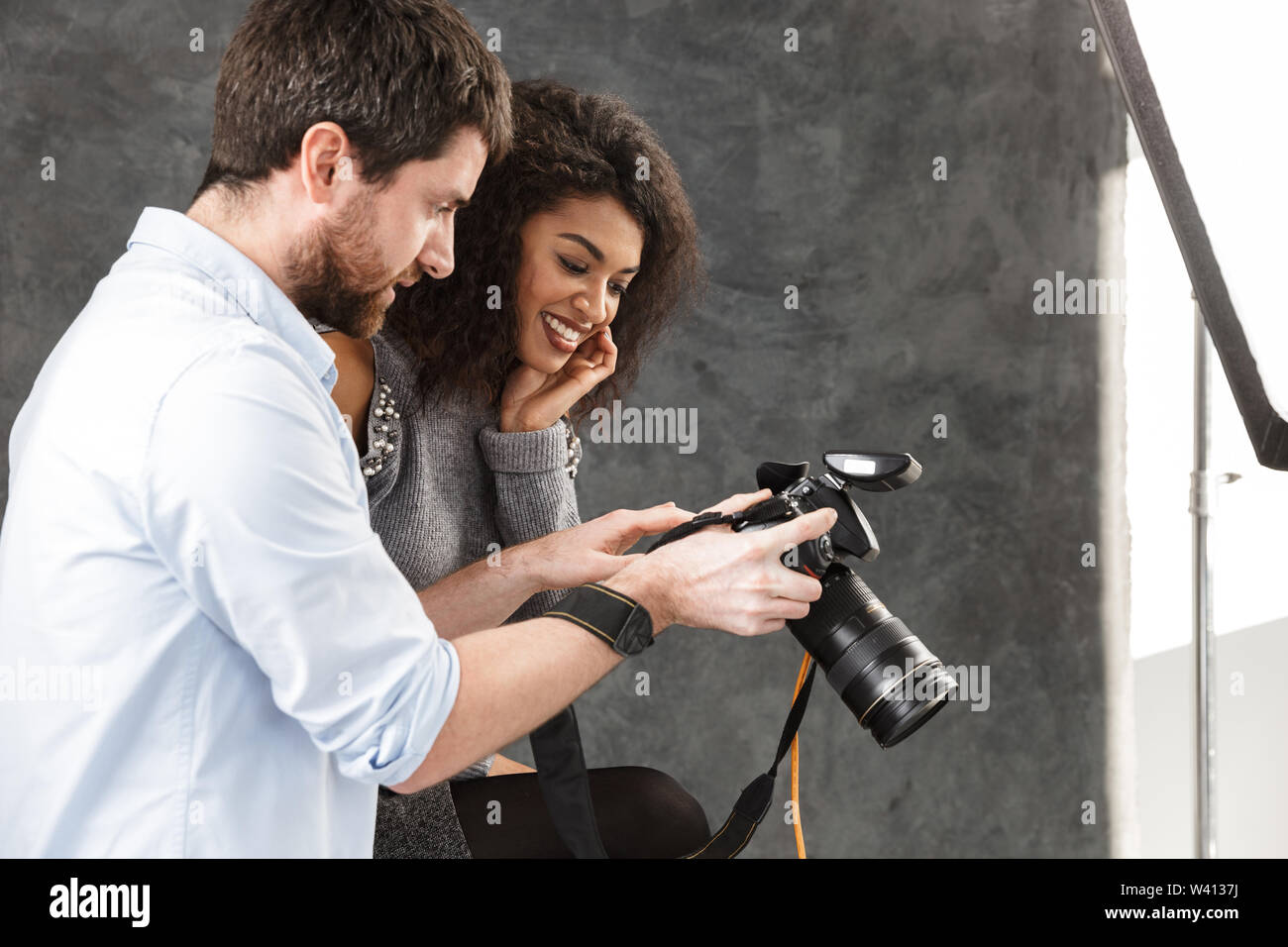 Portrait of handsome photographer man shooting satisfied african ...