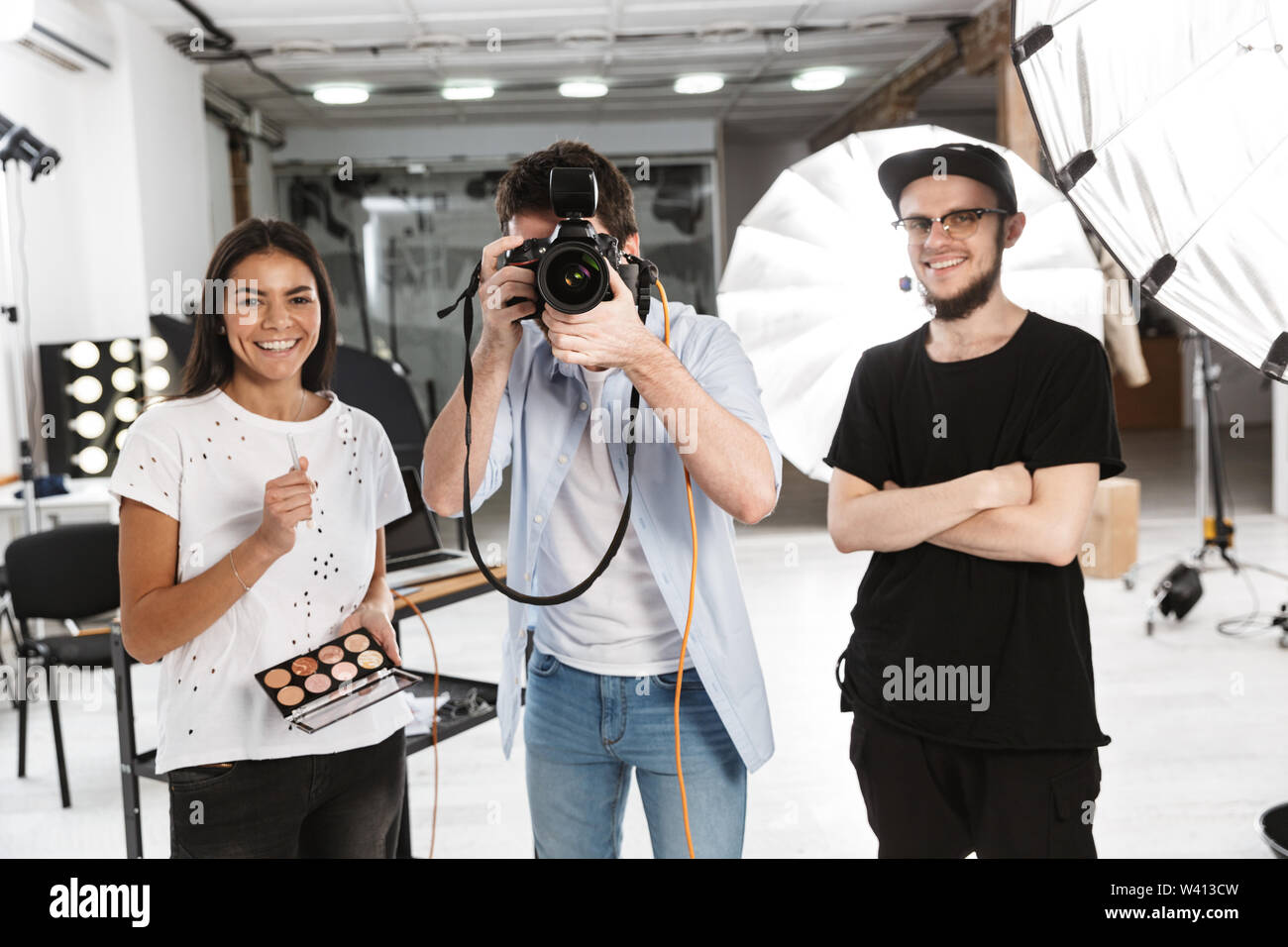 Portrait of smiling creative team photo shooting model with ...