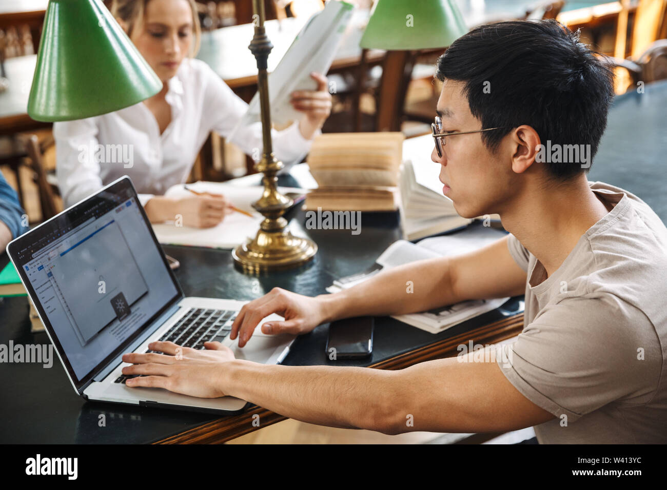 Smart pensive asian student studying with laptop at the library Stock ...