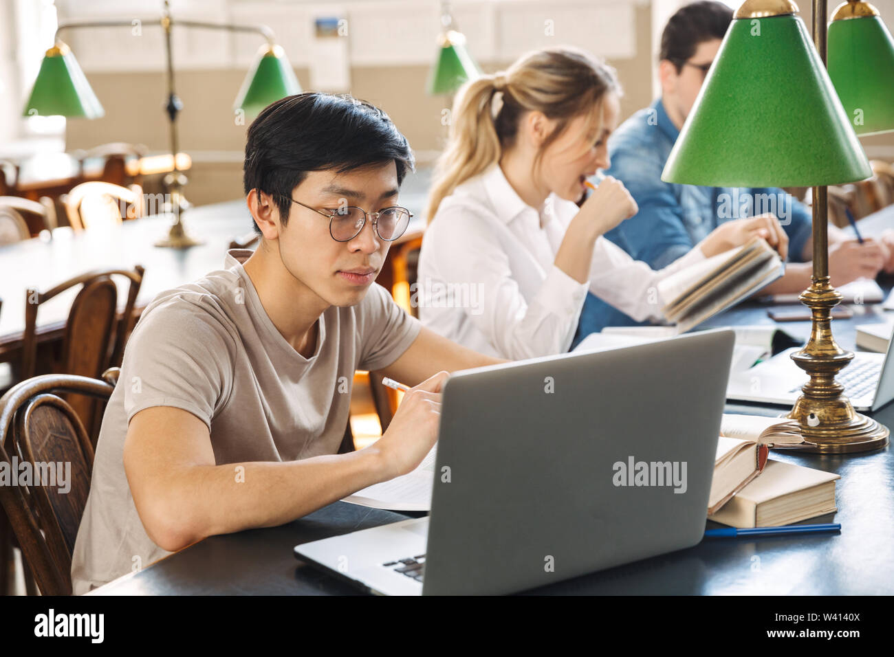 Smart pensive asian student studying with laptop at the library Stock ...