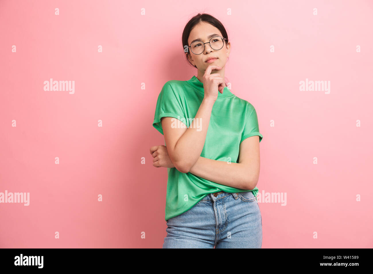 Photo of pretty young girl wearing round eyeglasses touching her chin ...
