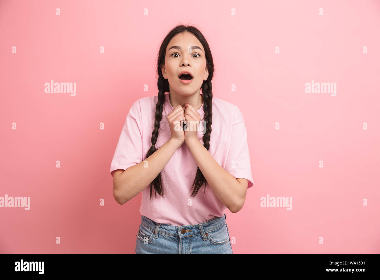 Image of optimistic pretty girl with two braids smiling at camera and ...