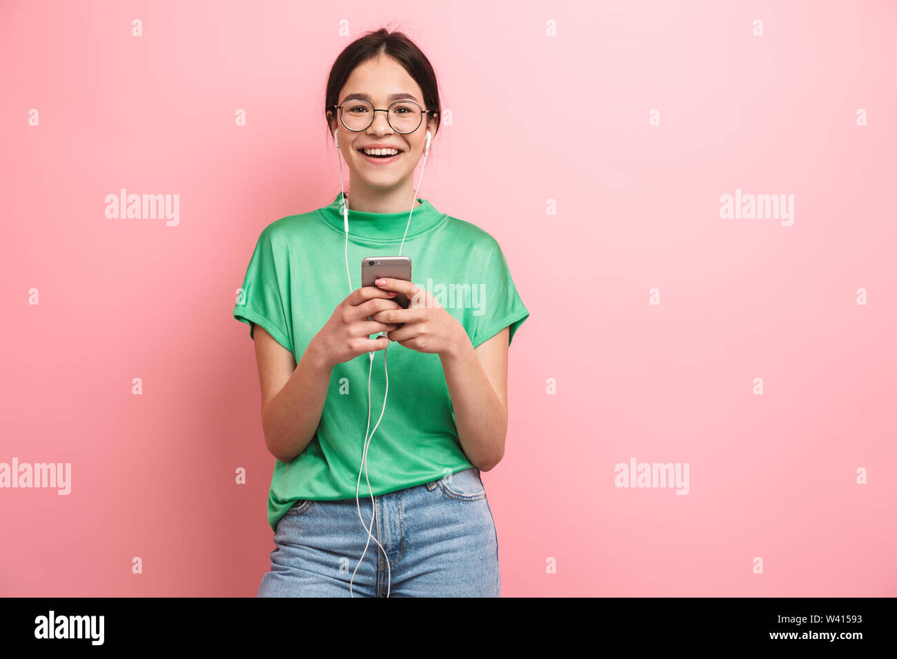 Photo Of Smiling Young Girl Wearing Round Eyeglasses Using Earphones