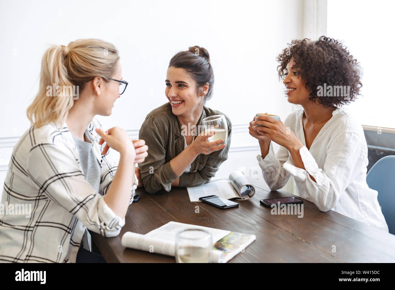 Group of multiethnic cheerful young women studying together at the ...