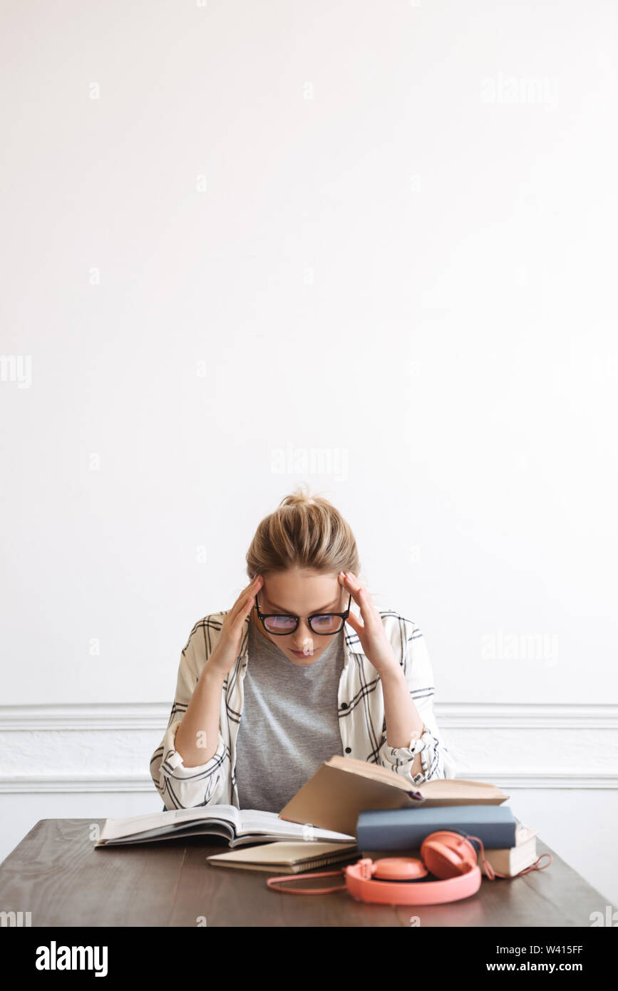 Attractive young girl student doing homework at the cafe indoors ...