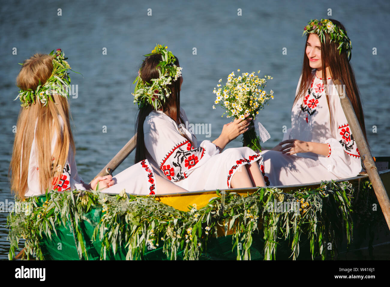 Midsummer. Young Girls in national costumes sail in a boat that is ...