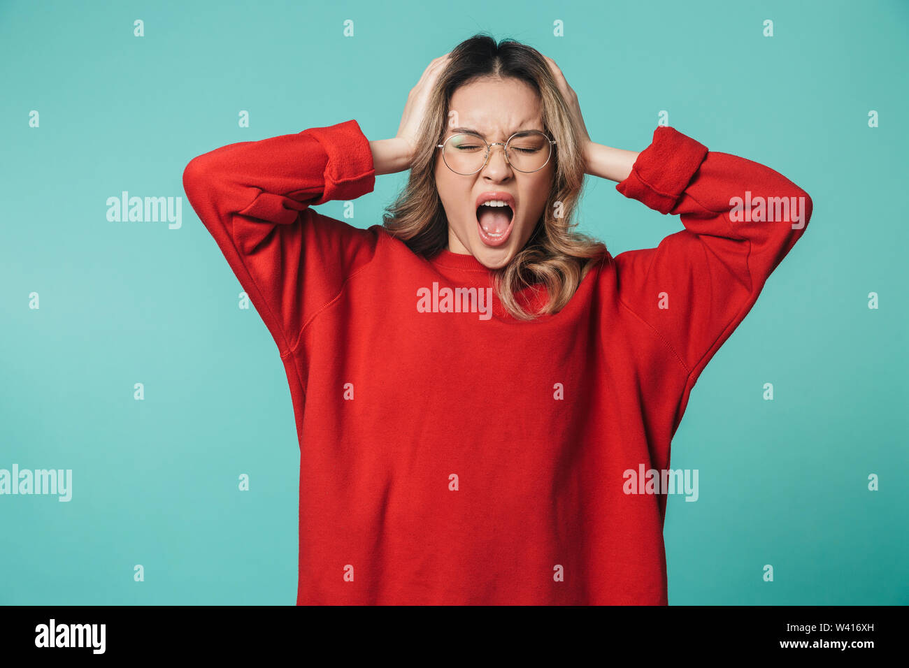 Image of screaming stressed young woman posing isolated over blue wall ...