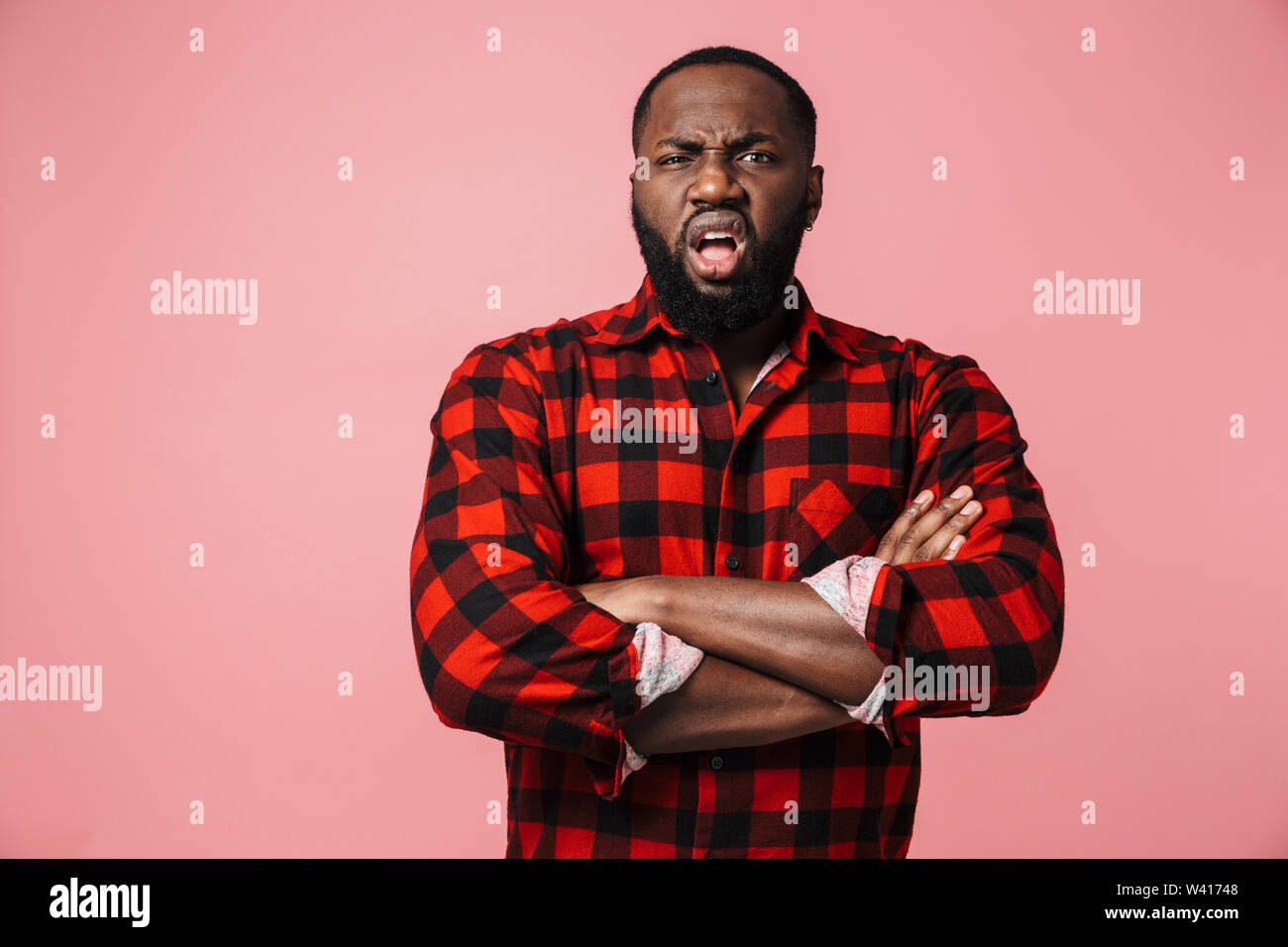 Portrait of a confused african man wearing plaid shirt standing ...