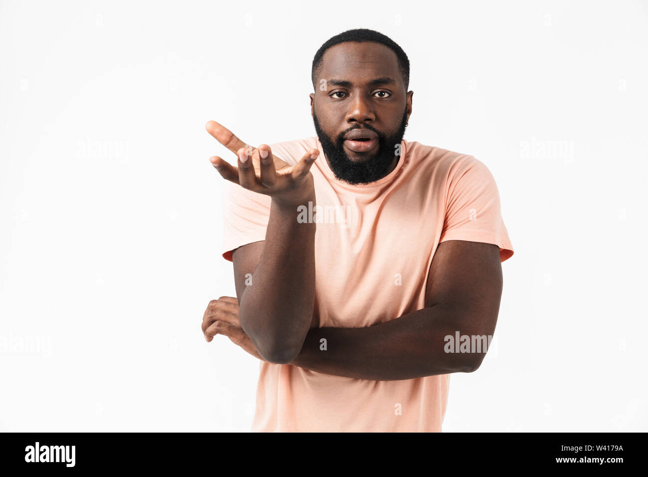 Portrait of a confused african man wearing t-shirt standing isolated ...